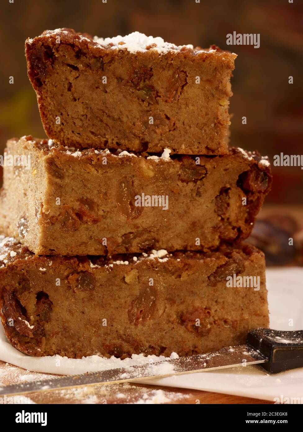 Sliced Bread Pudding and icing sugar on greaseproof paper as if waiting ...