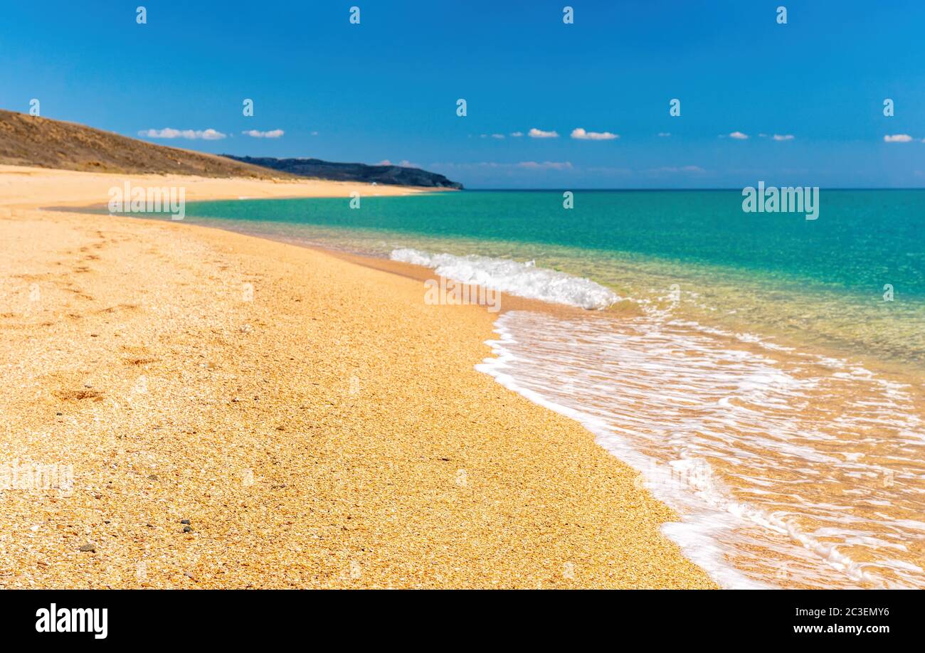 Empty, deserted golden beach with shell sand and crystal clear azure ...