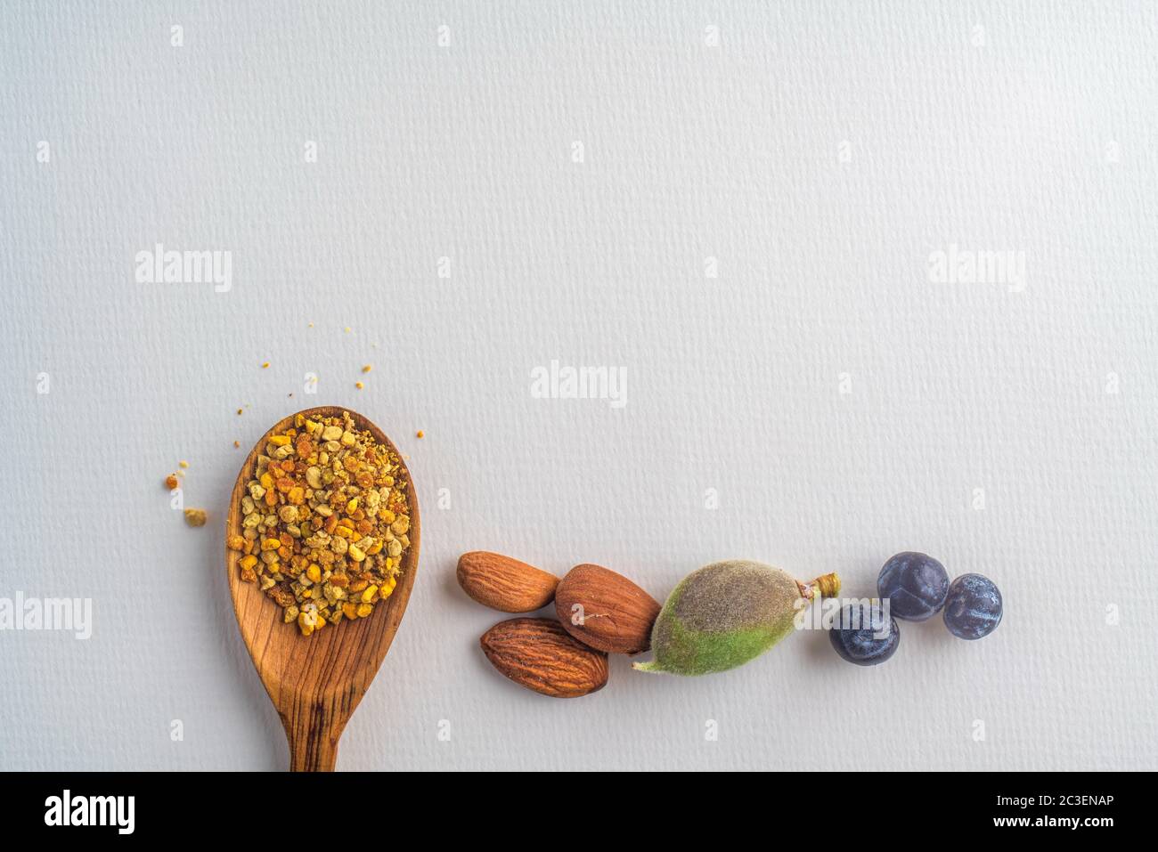 Three juniper blue old berries, almonds nut and bee pollen in wooden ...
