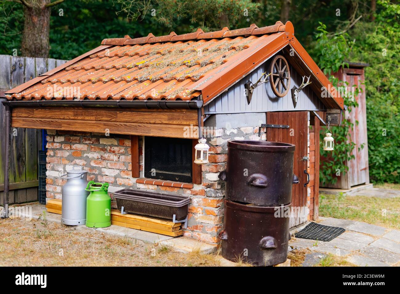 Brick shed or hut with antlers and cart wheel decoration over doors ...
