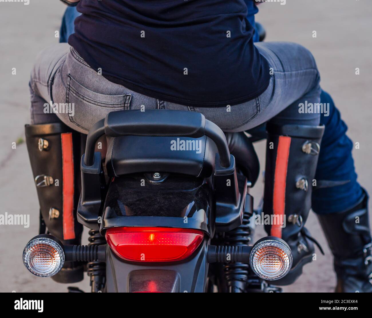 ass and legs of a young biker woman sitting on a motorcycle rear view ...