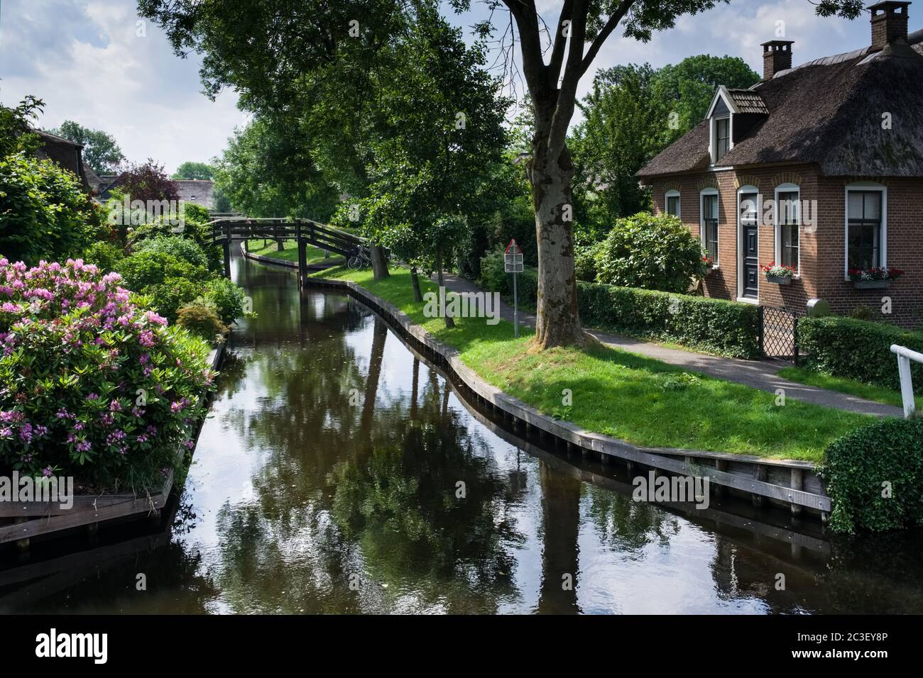 2020: Landscape view of famous Giethoorn village with canals, bridges and rustic thatched roof ...