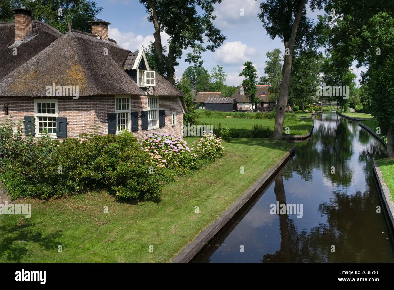 2020: Landscape view of famous Giethoorn village with canals, bridges and rustic thatched roof ...