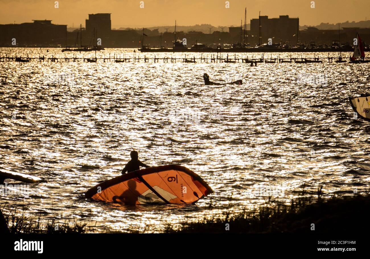 Poole, UK. 19th June 2020. Sunset makes for a fiery sky as people enjoy ...
