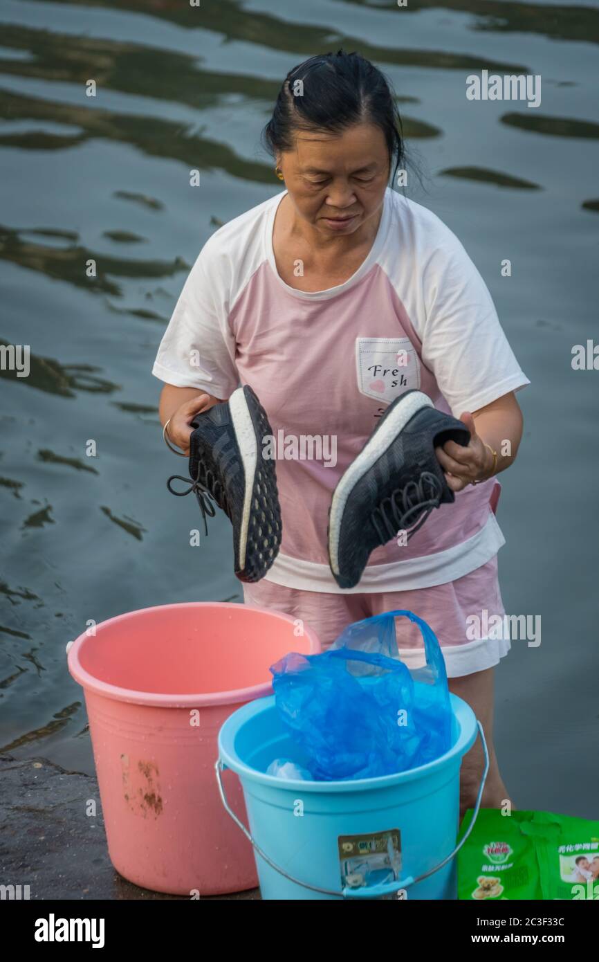 Chinese woman washing shoes in the river Stock Photo - Alamy