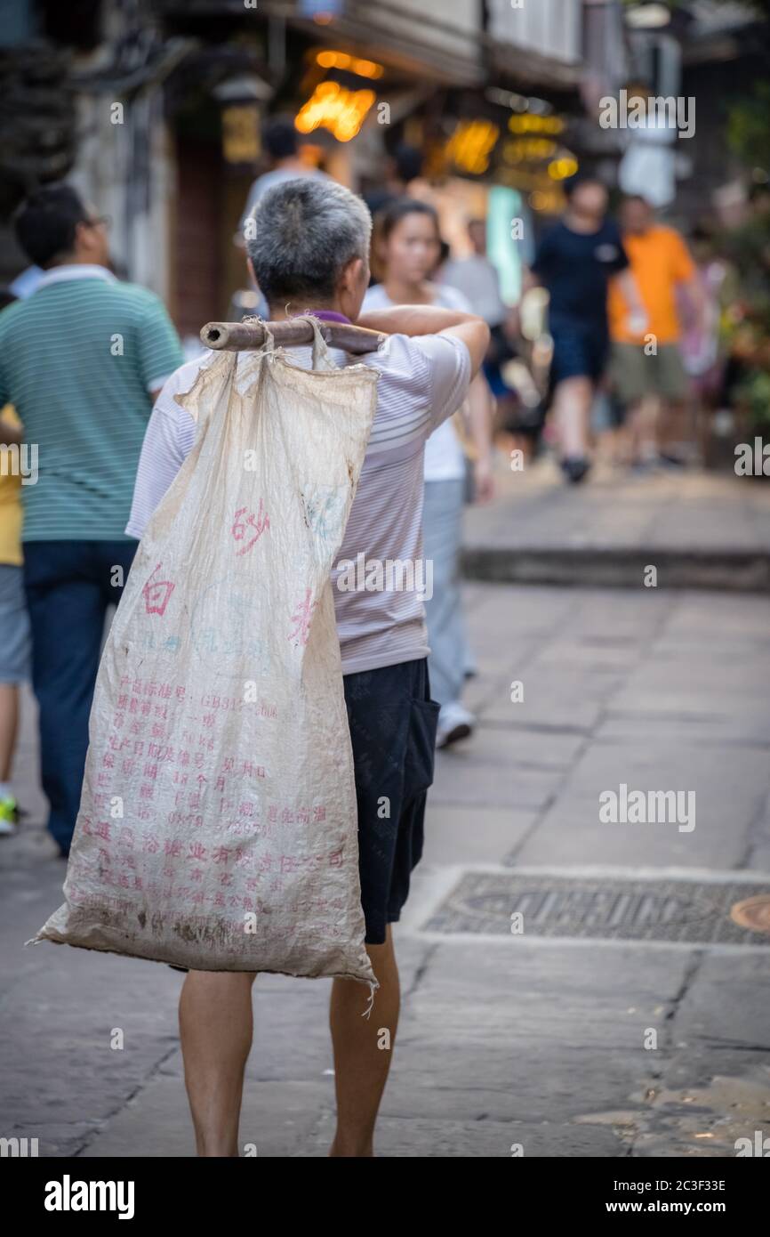Chinese man carrying heavy load Stock Photo - Alamy