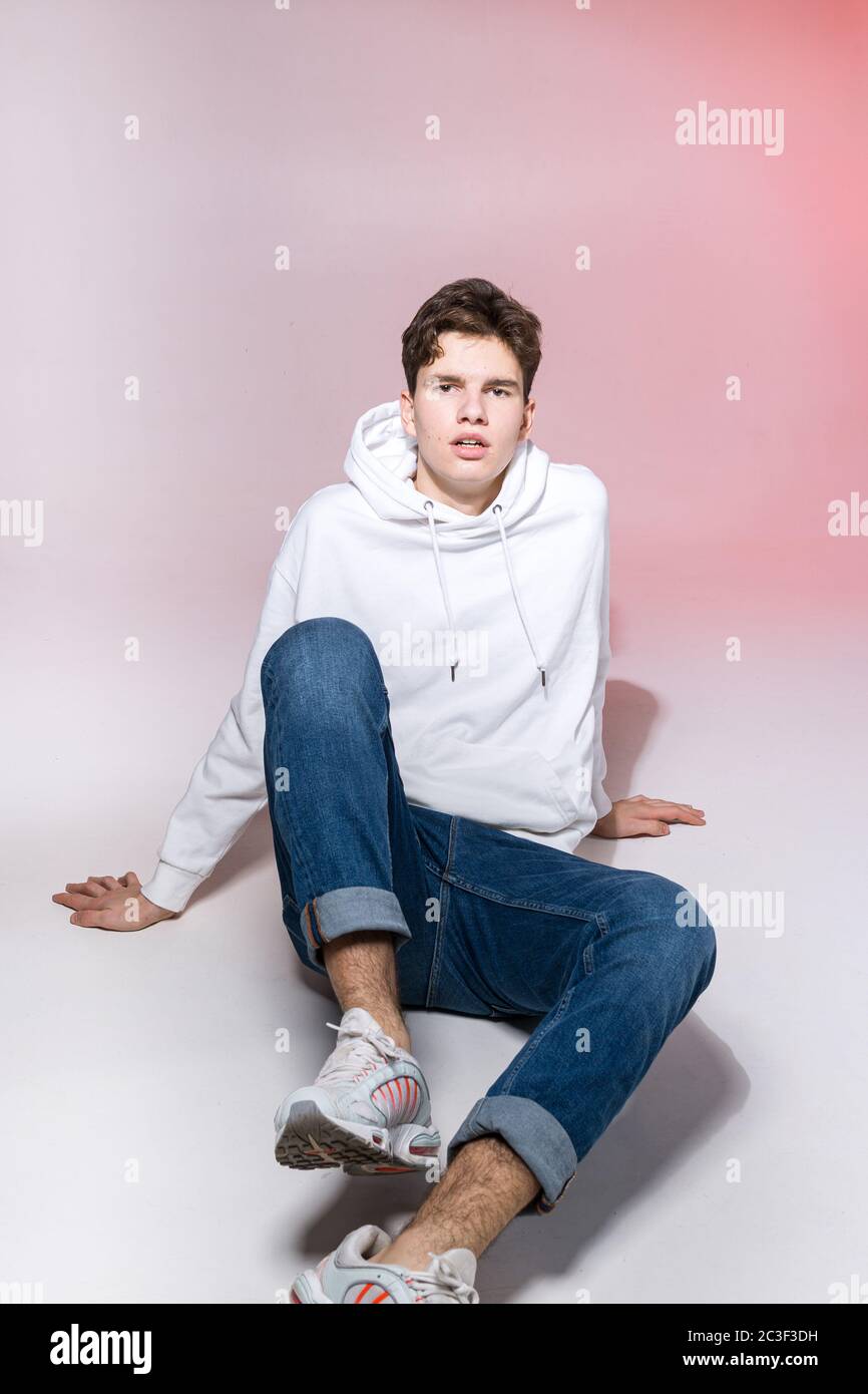 Young caucasian male model posing while sitting on the floor in the ...