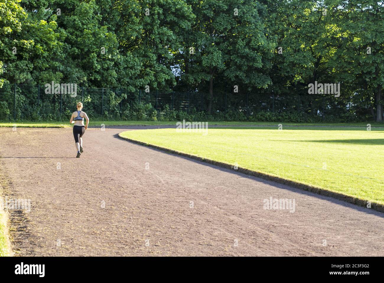 Woman (38) runs on a sand track, Kiel, Schleswig-Holstein, Germany ...