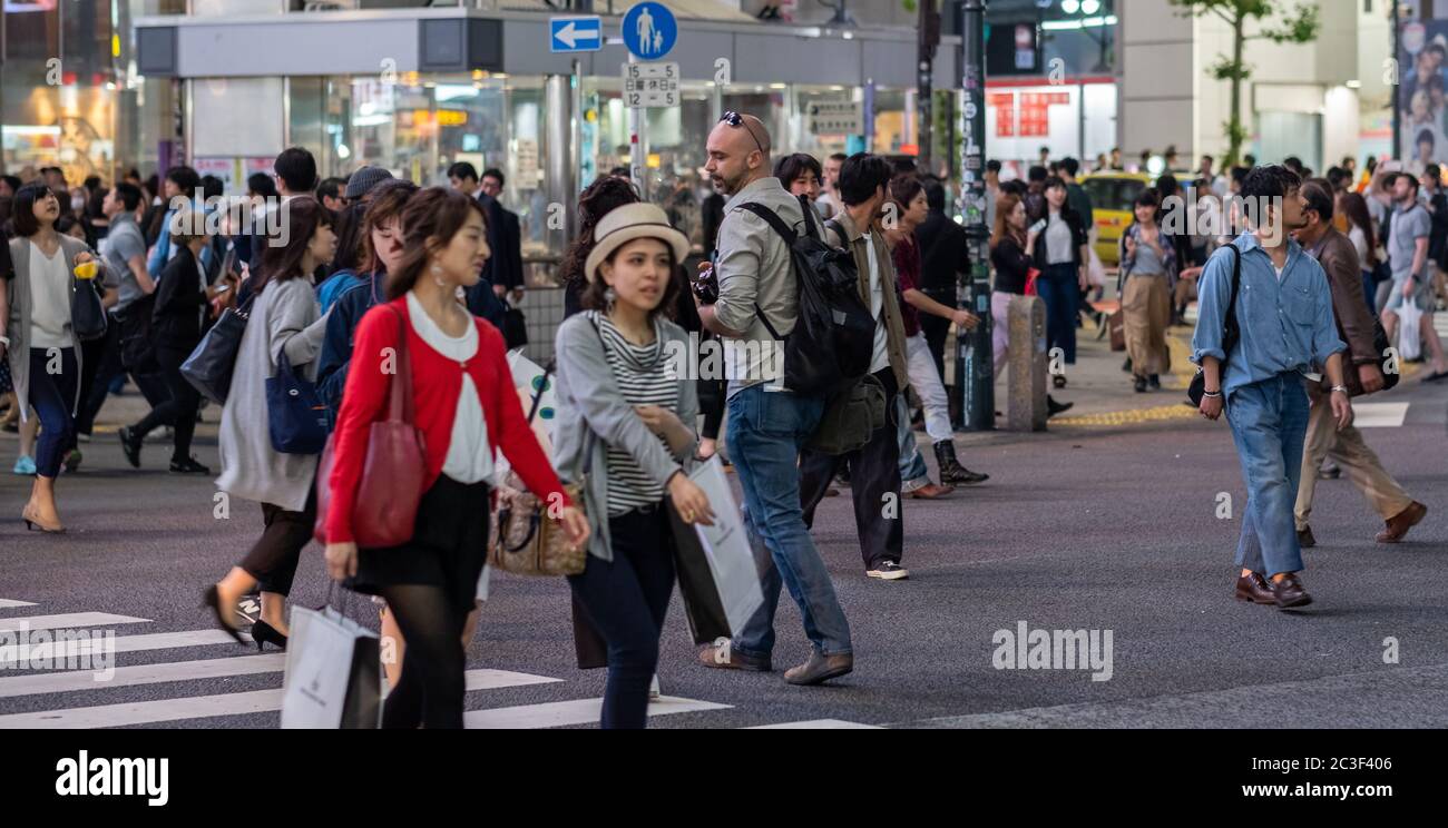 Mass crowd walking across the famous Shibuya pedestrian scramble ...