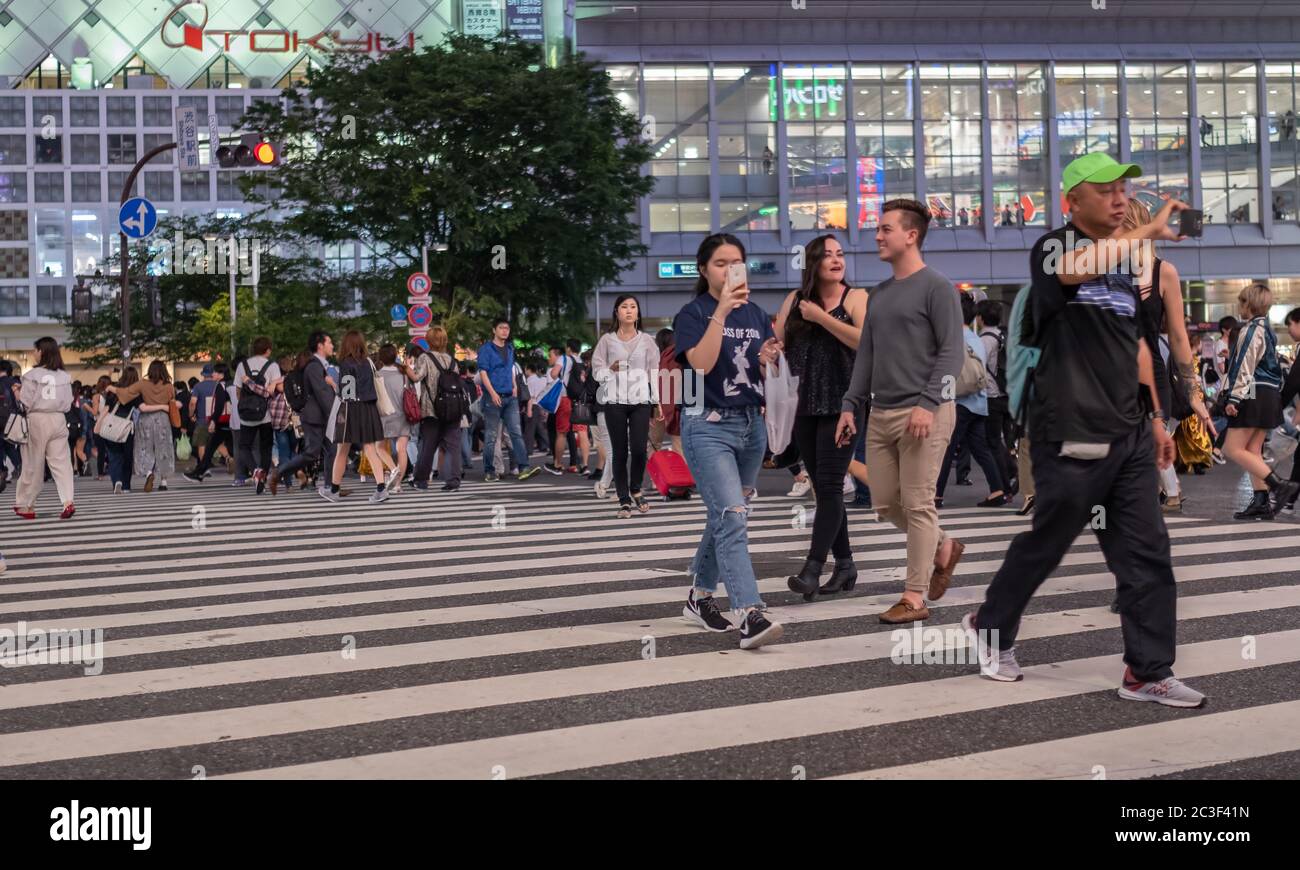 Mass crowd walking across the famous Shibuya pedestrian scramble ...