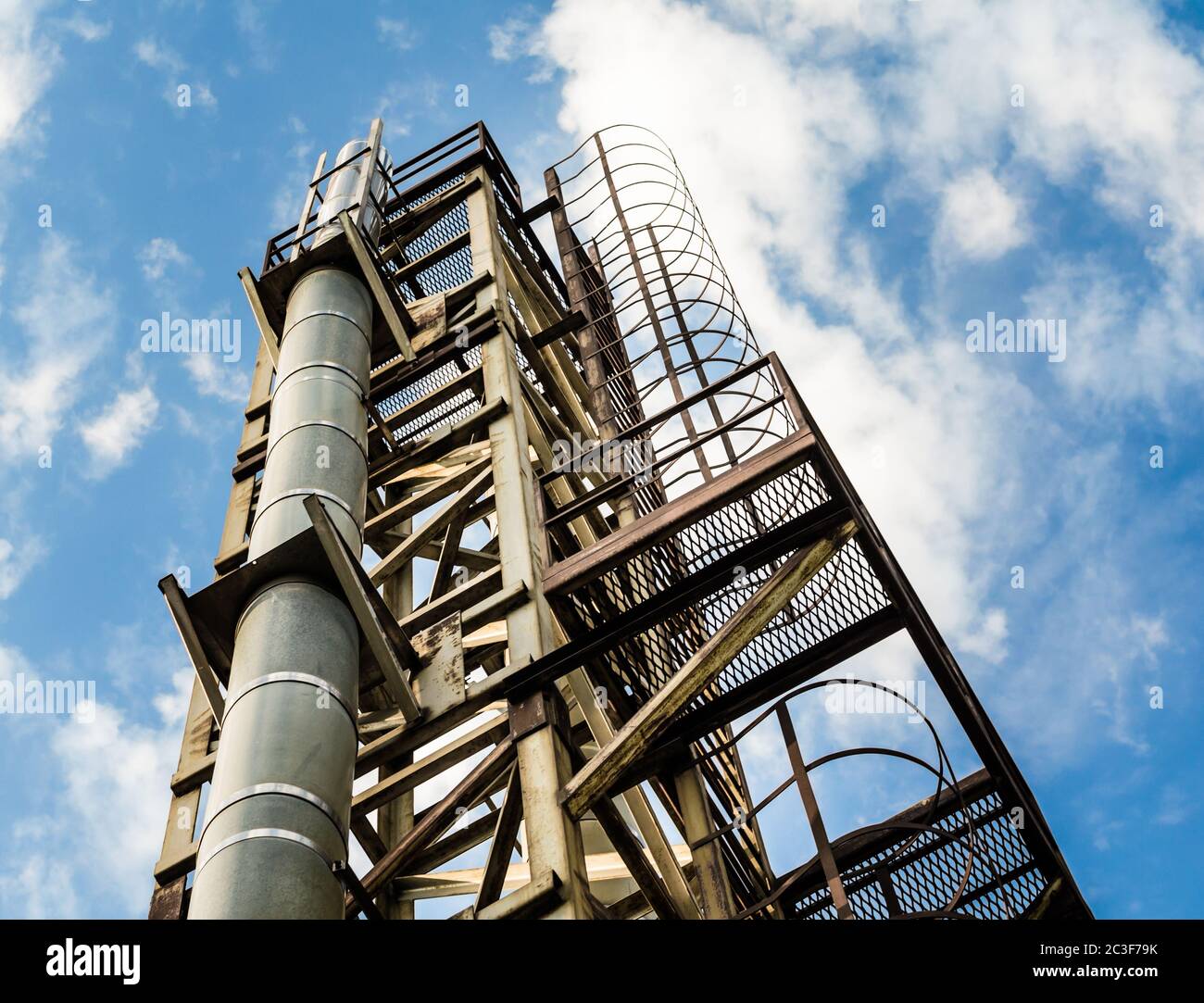 tower with a pipe and a ladder against a blue sky and clouds Stock ...
