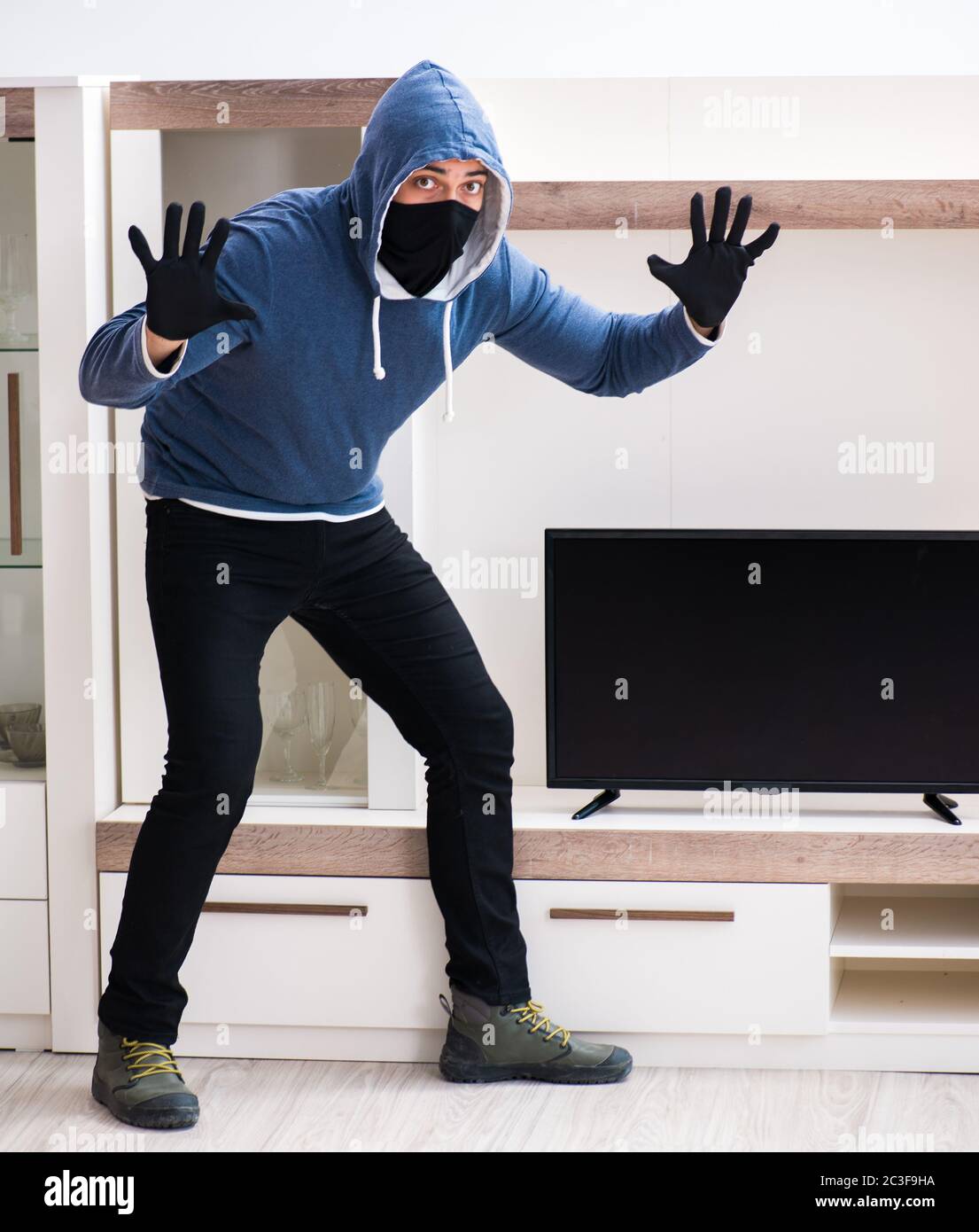 Man burglar stealing tv set from house Stock Photo - Alamy