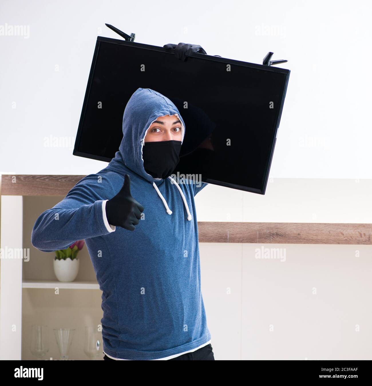 Man burglar stealing tv set from house Stock Photo - Alamy
