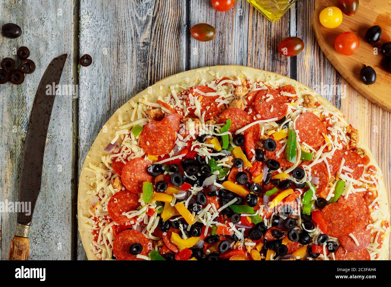 Pizza with black olives, pepperoni, sausage, pepper and cheese ...