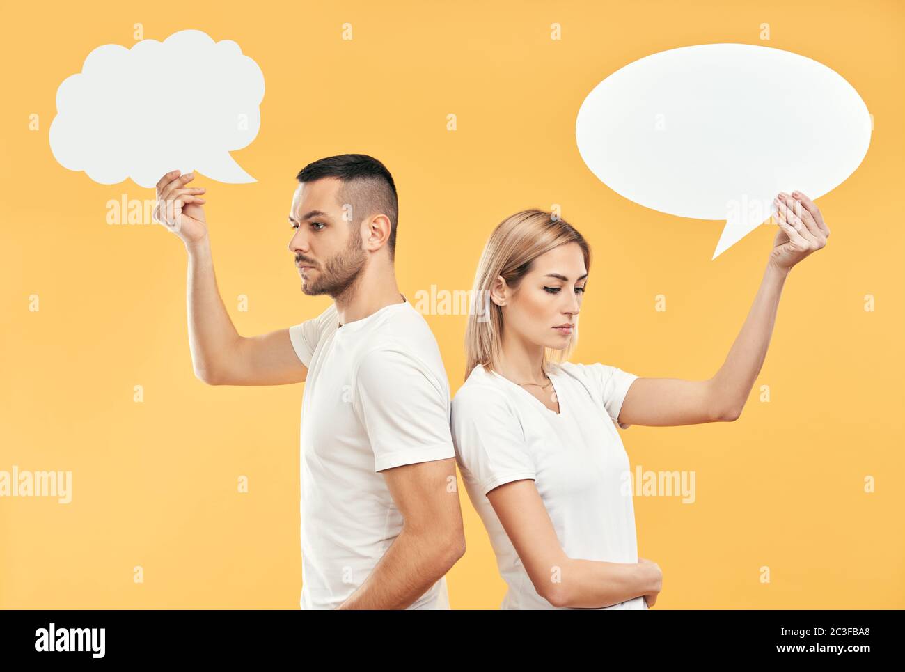 Upset woman and man holding paper thought bubbles over yellow ...