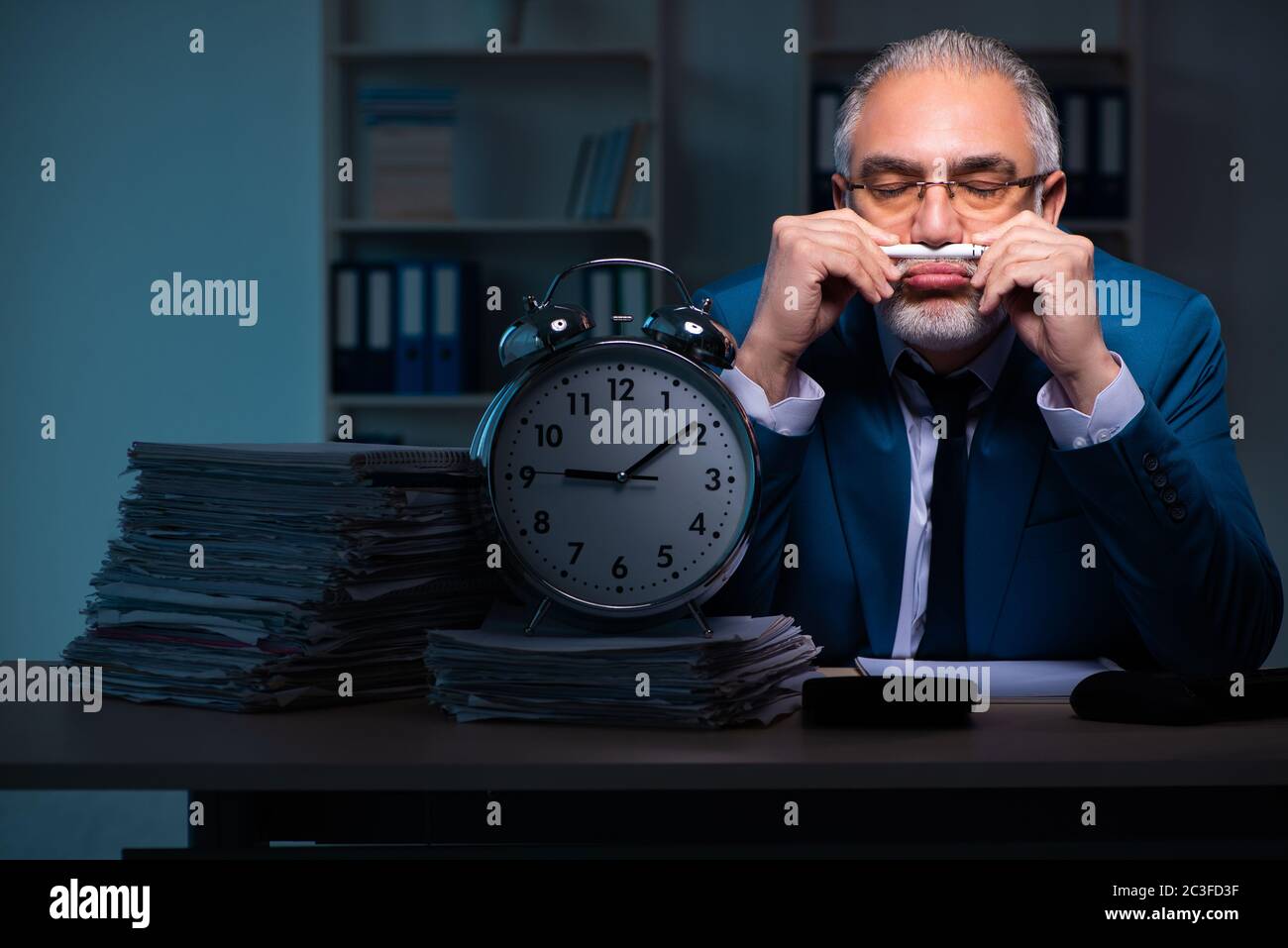 Old male employee working late in the office Stock Photo - Alamy