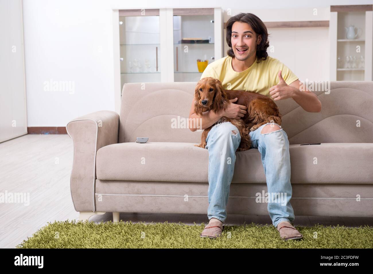 Young man with cocker spaniel dog Stock Photo - Alamy