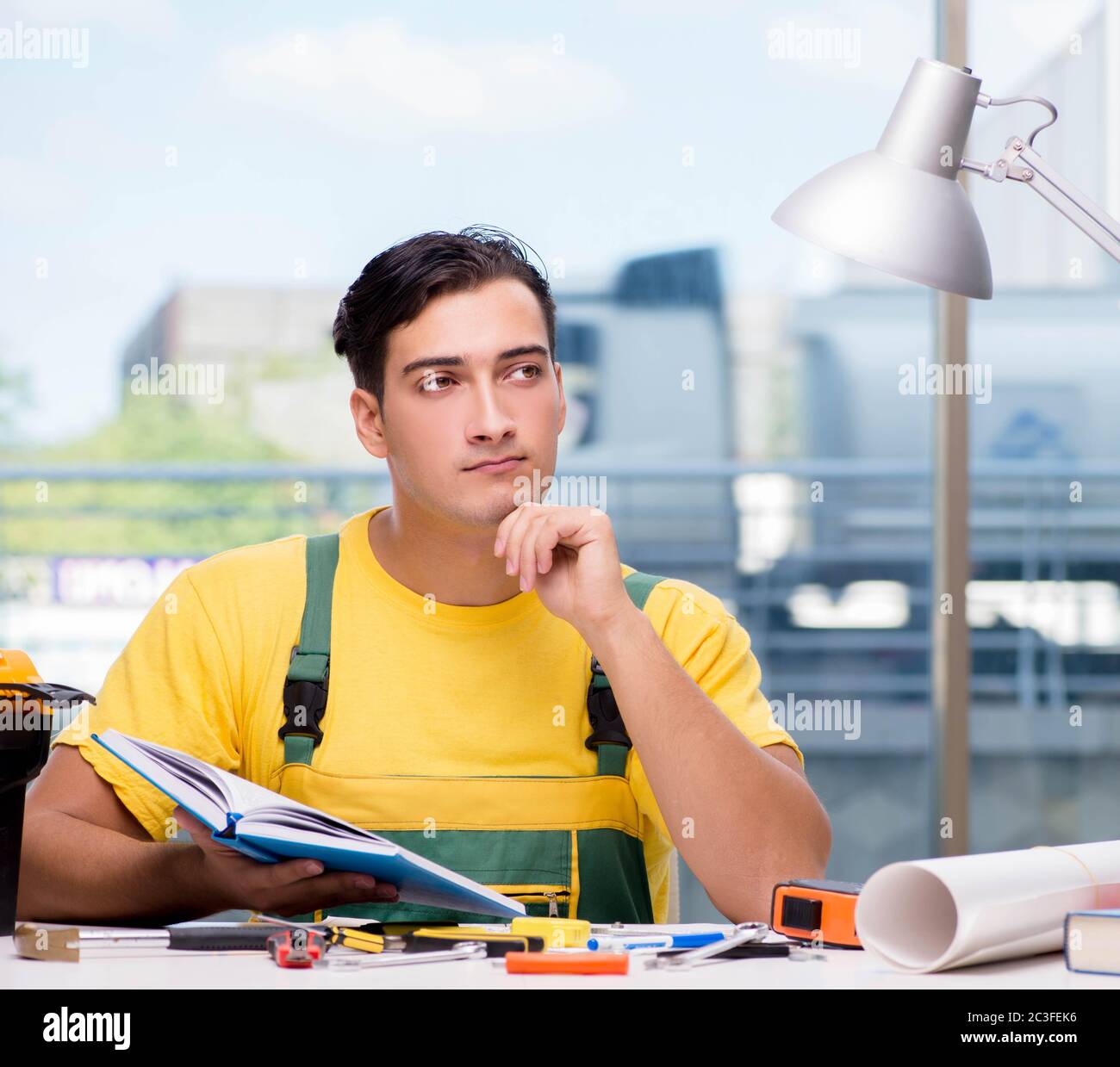 Construction worker sitting at the desk Stock Photo - Alamy