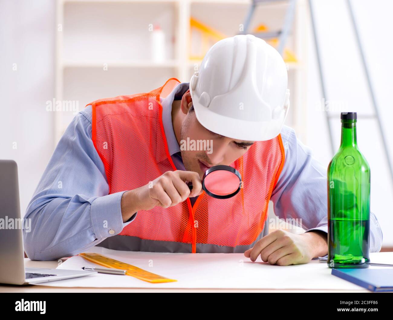 Drunk engineer working in the workshop Stock Photo - Alamy