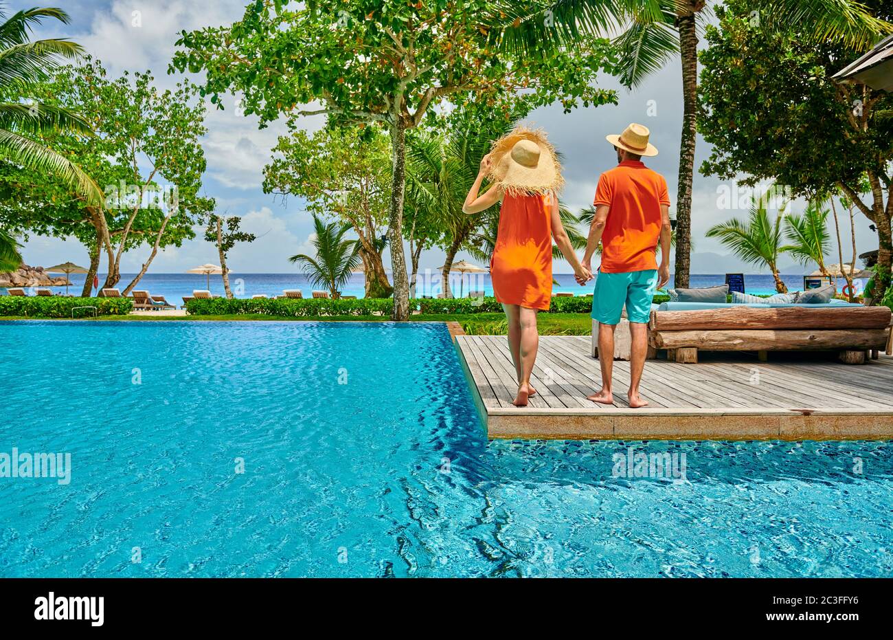 Young couple by poolside. Resort swimming pool at Seychelles Stock ...
