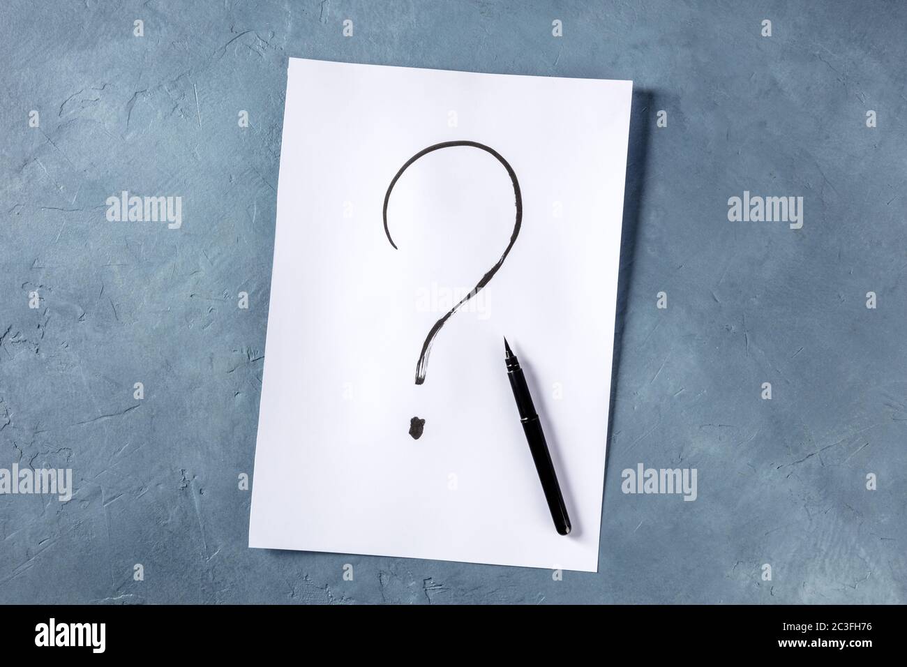 Question mark, written in ink on a piece of standard office paper, shot ...