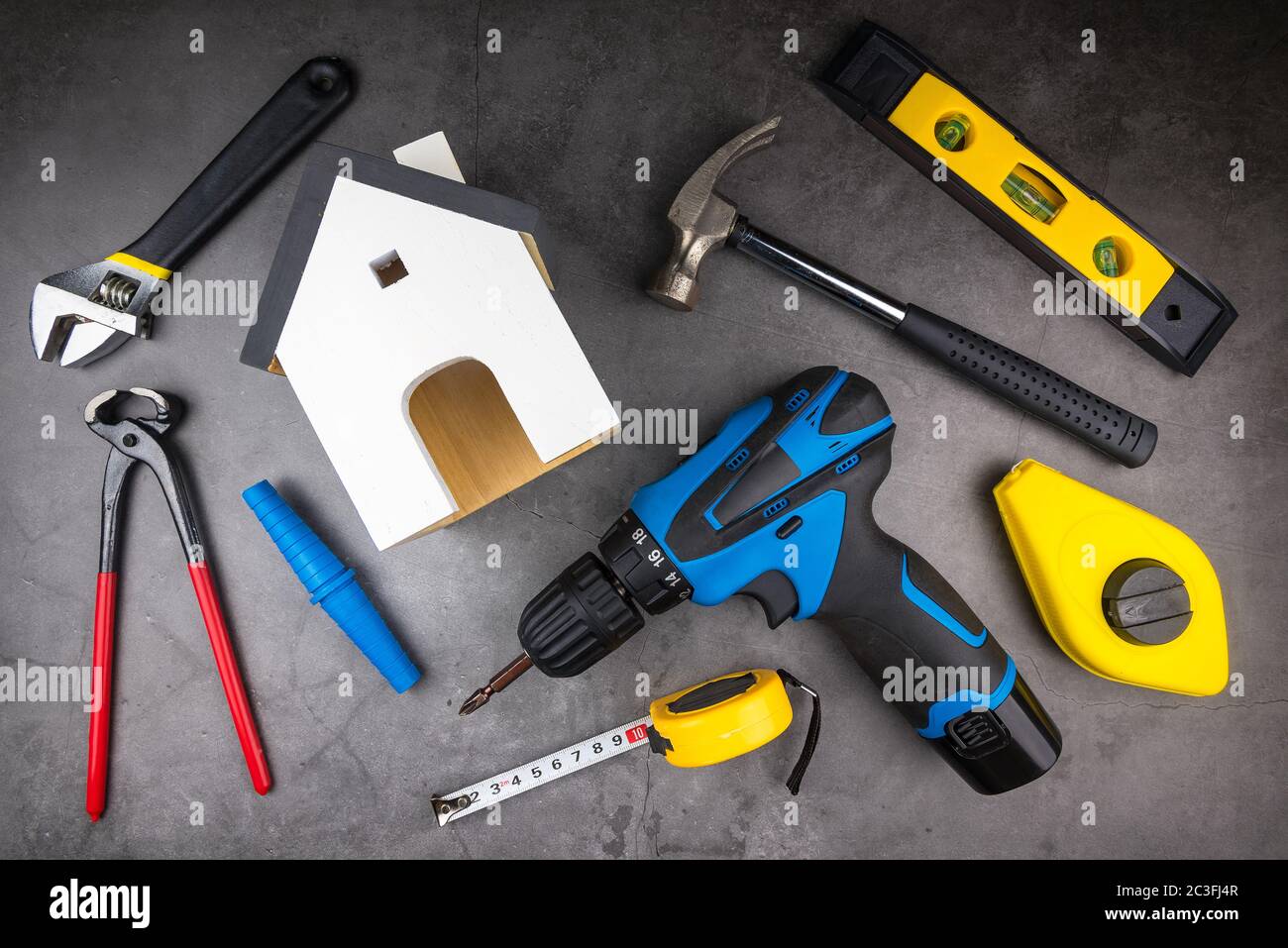 Wooden model white houses and Home Repair Hand Tools on a cement gray ...