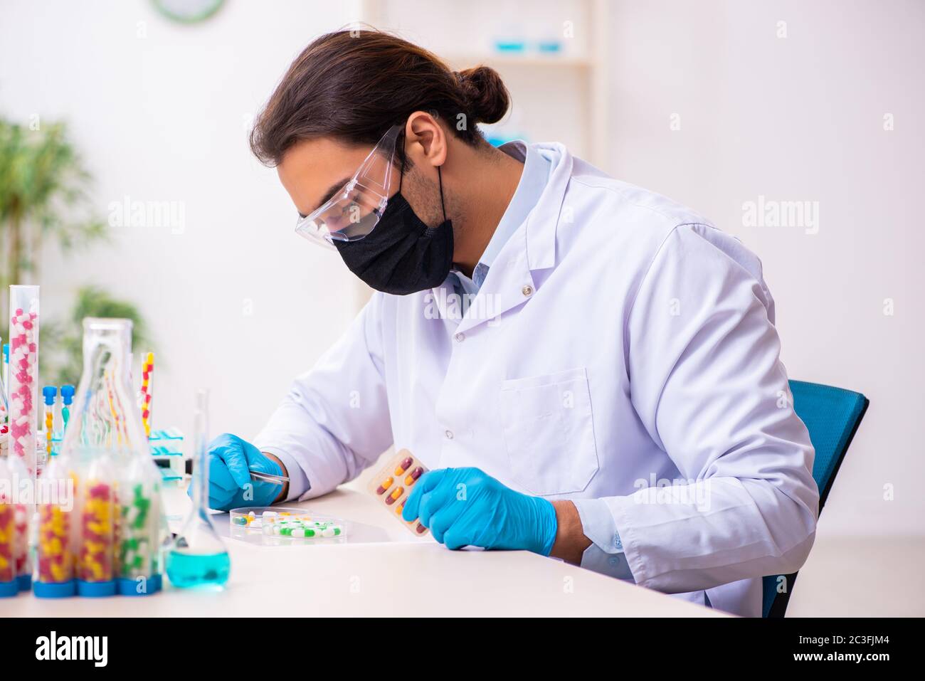 Young male chemist in drug synthesis concept Stock Photo - Alamy