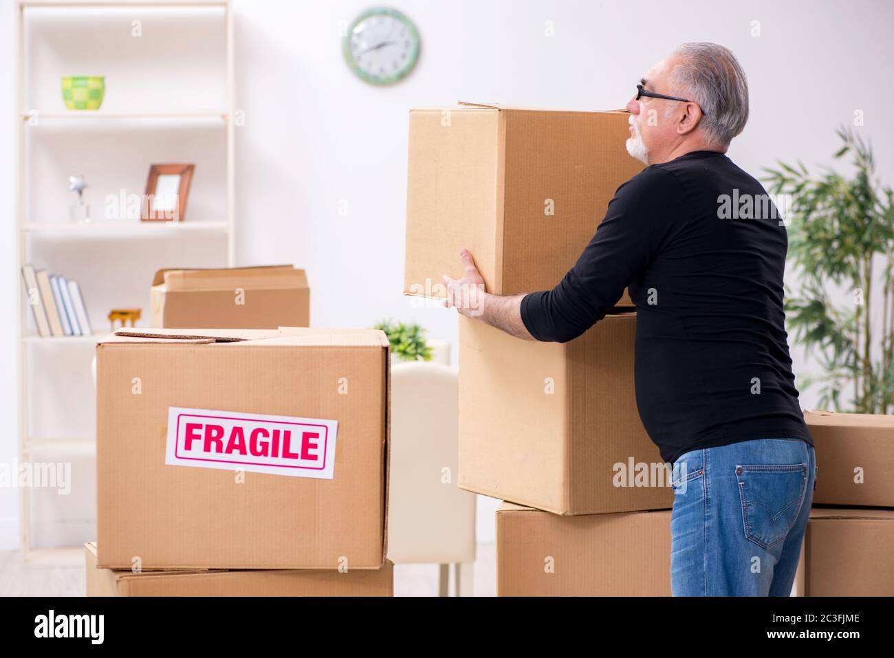 Old male professional mover doing home relocation Stock Photo - Alamy
