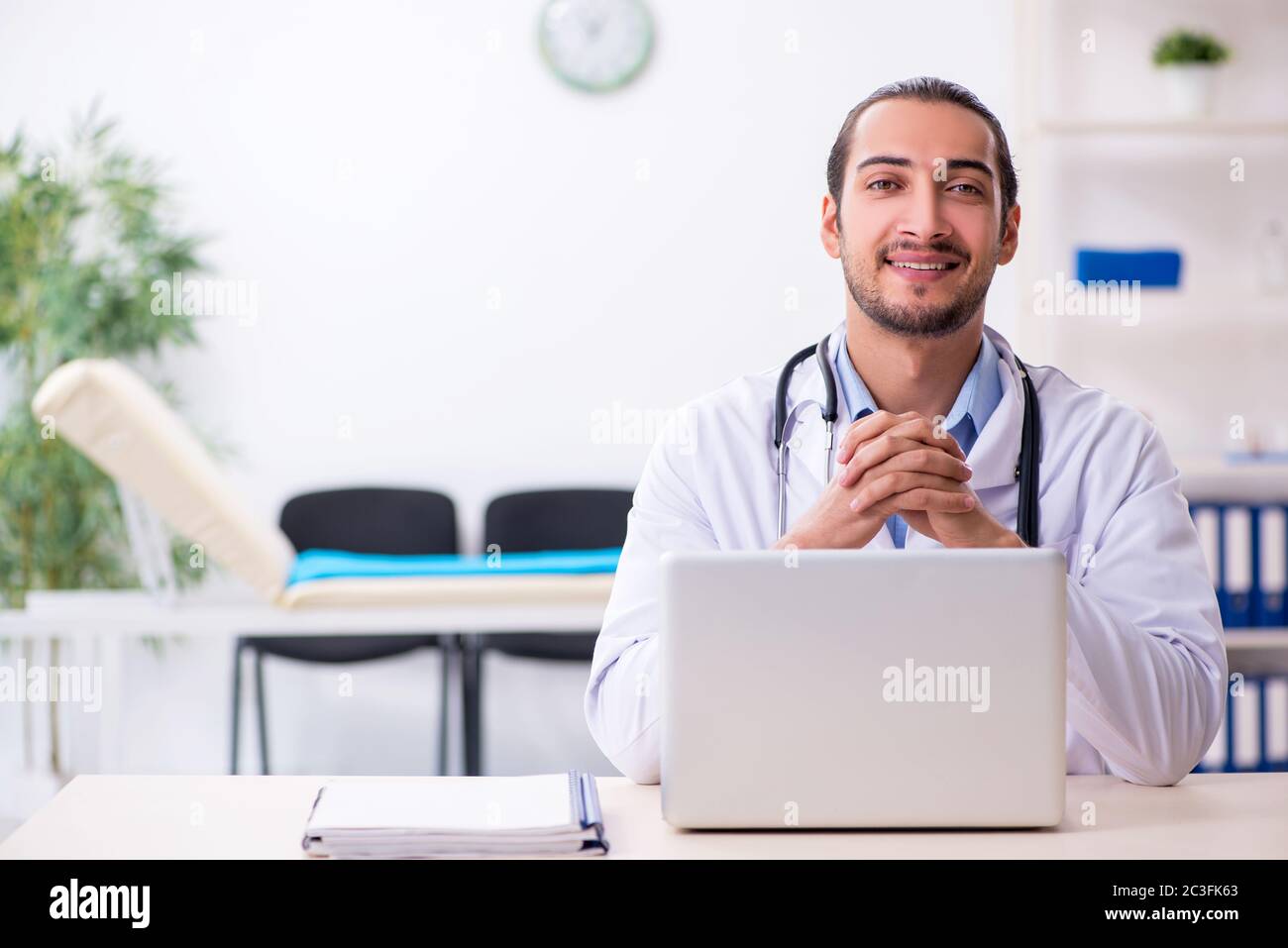 Young handsome male doctor working in the clinic Stock Photo - Alamy