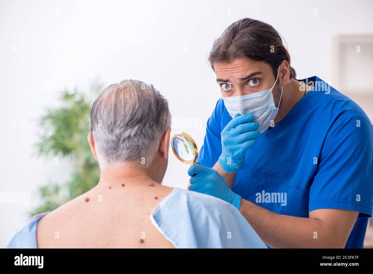 Old man visiting young male doctor dermatologist Stock Photo - Alamy