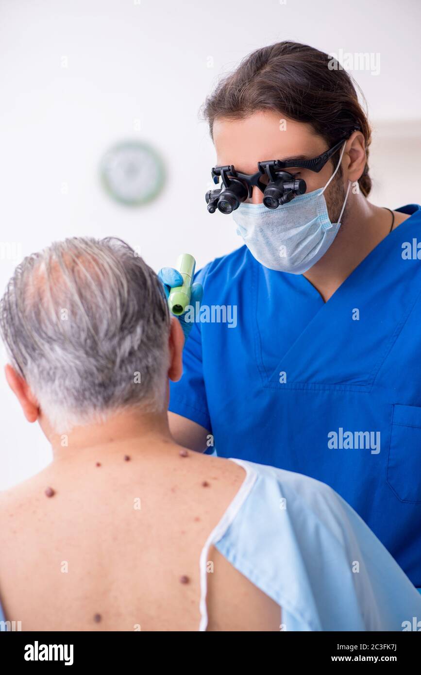 Old man visiting young male doctor dermatologist Stock Photo - Alamy