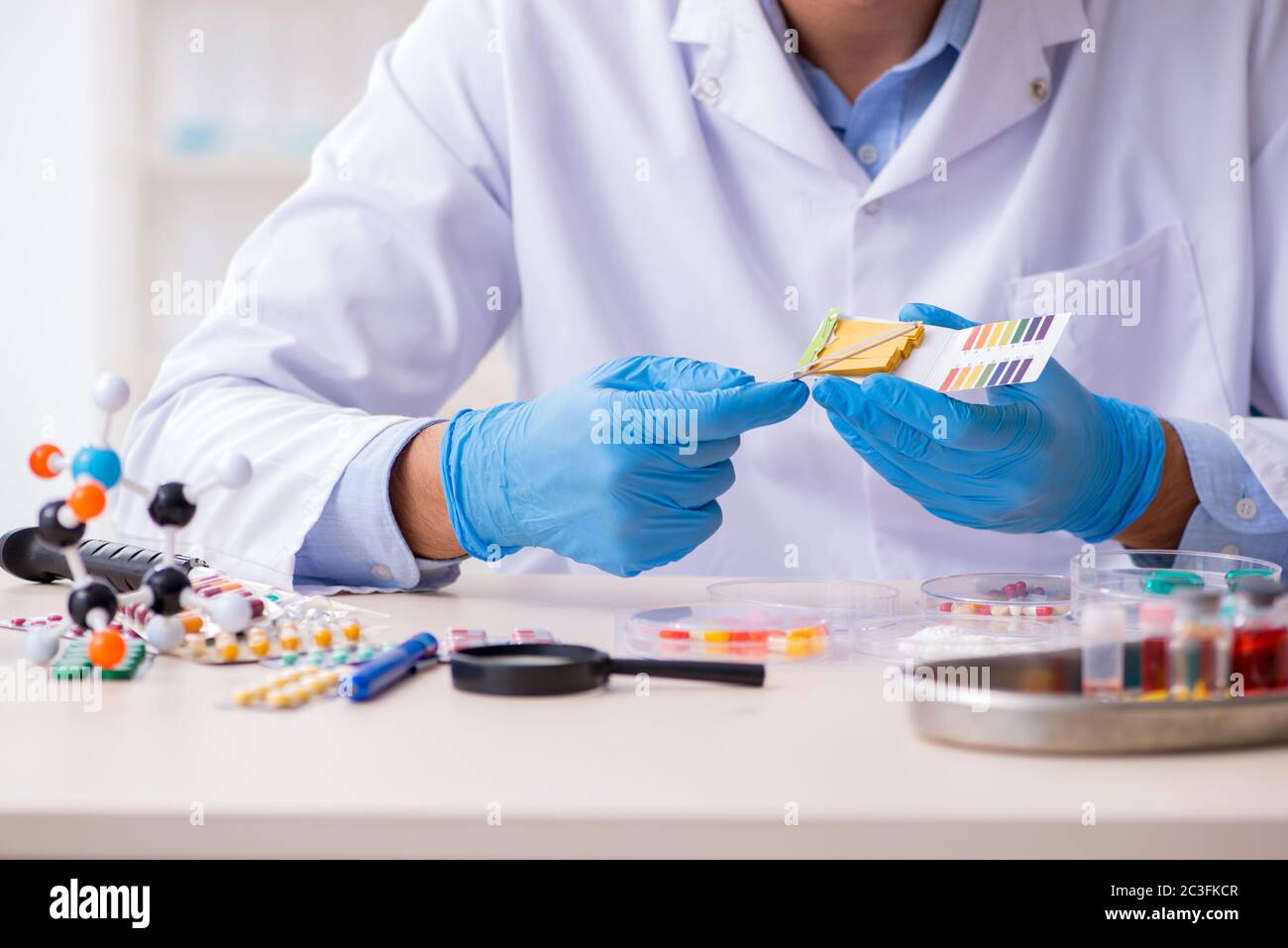 Young male lab assistant in drug synthesis concept Stock Photo - Alamy