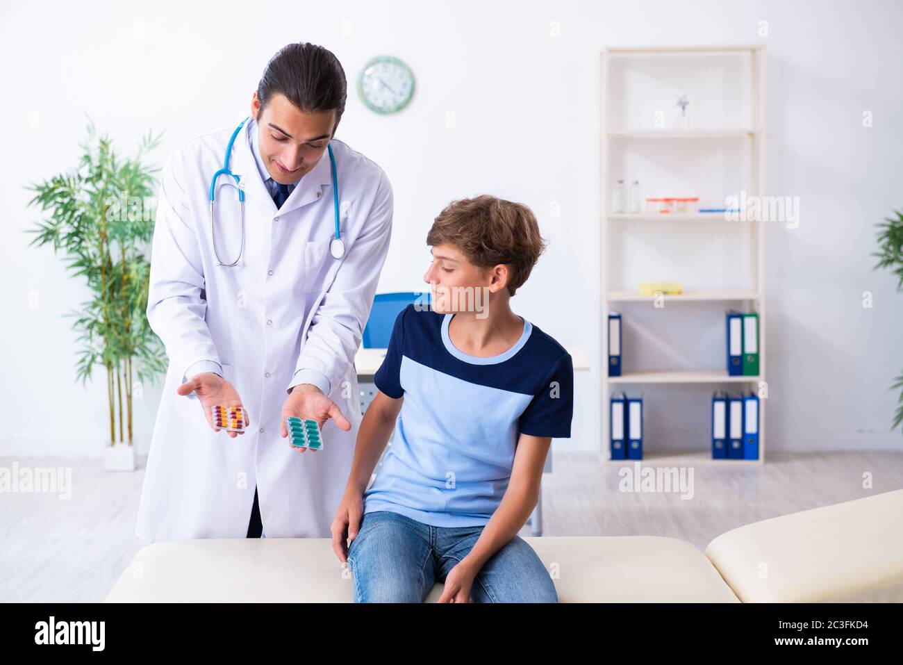 Young male doctor examining boy in the clinic Stock Photo - Alamy