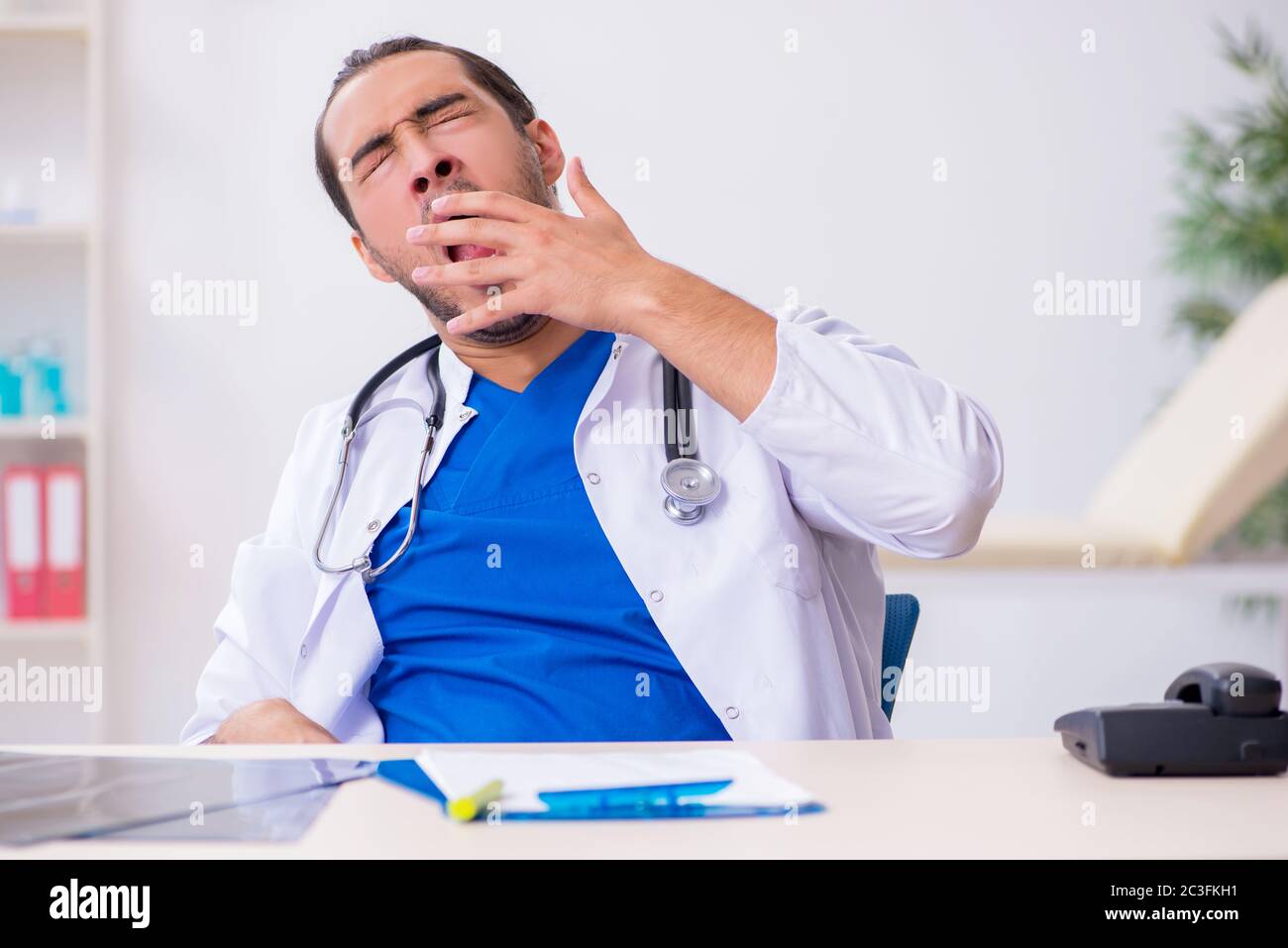 Young male doctor being tired after night shift Stock Photo - Alamy