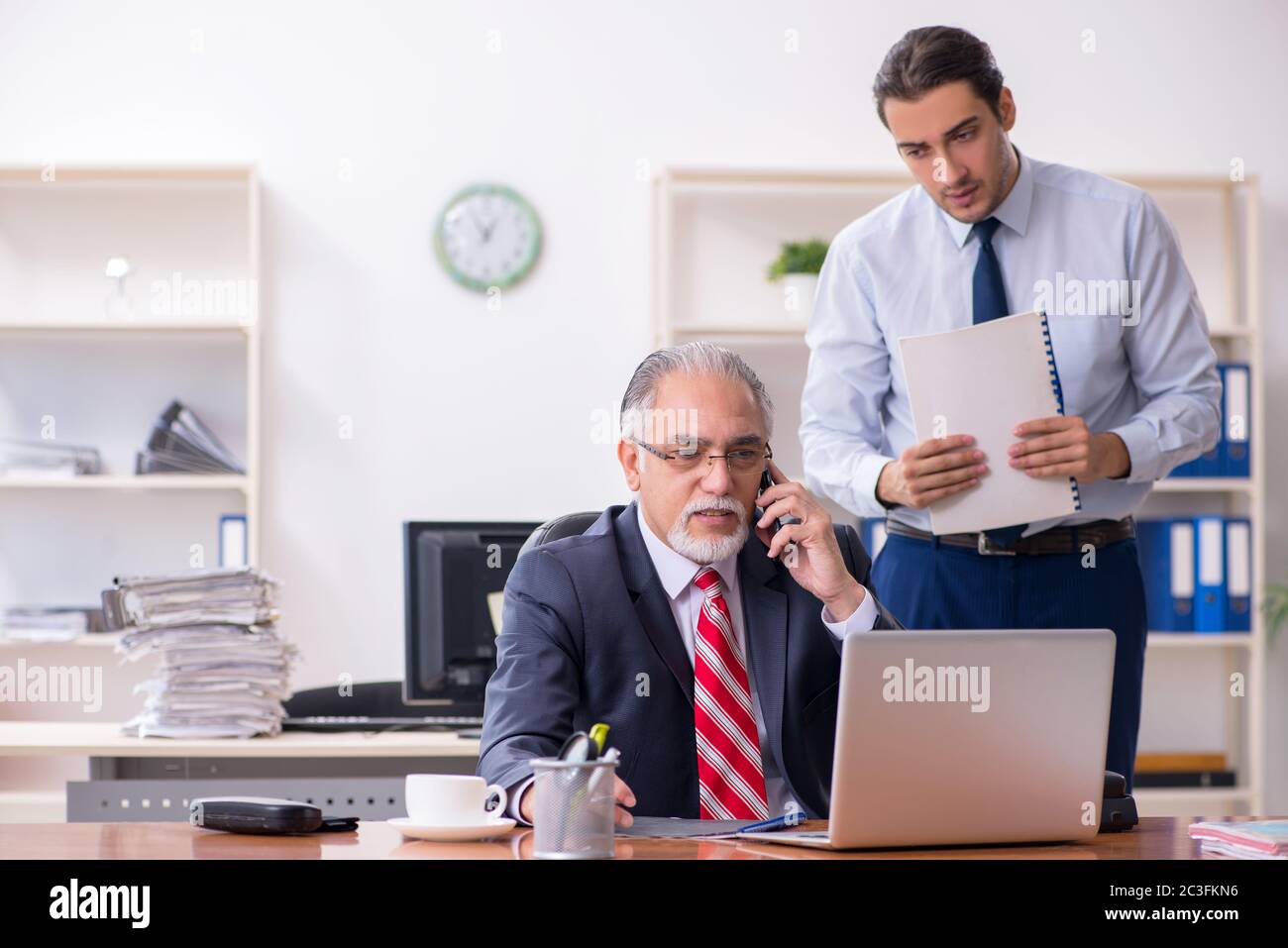 Old boss and young male employee in the office Stock Photo - Alamy