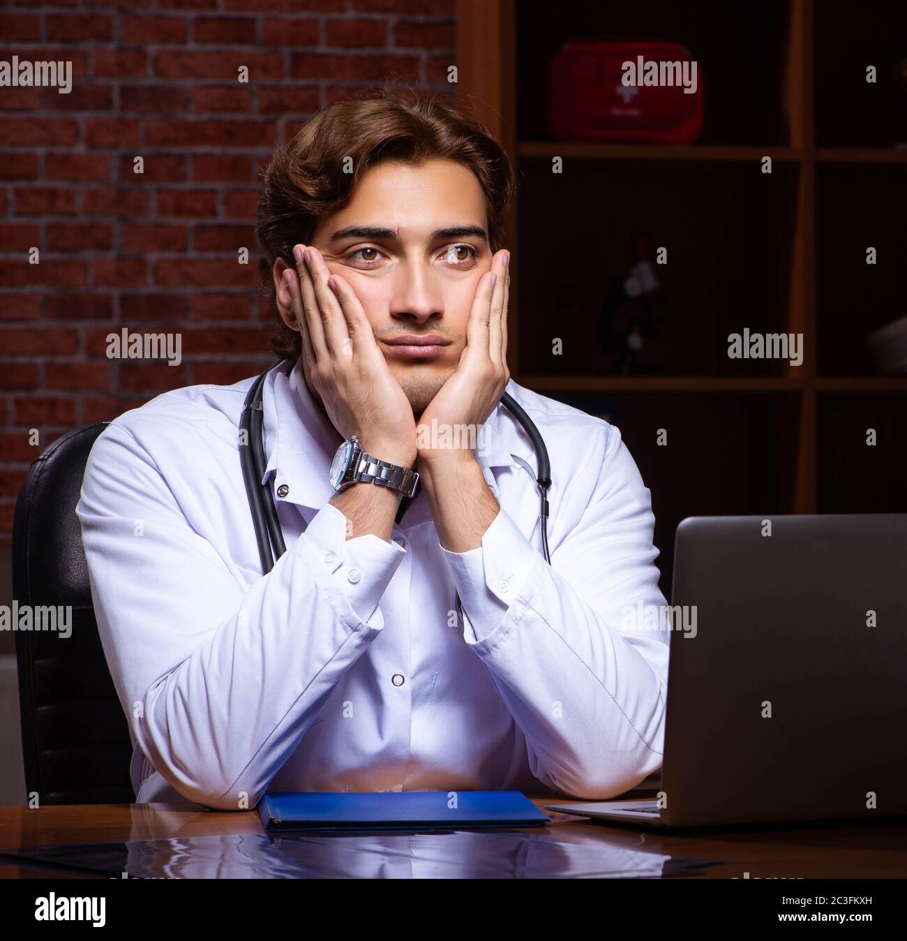 Young handsome doctor working night time at the hospital Stock Photo ...