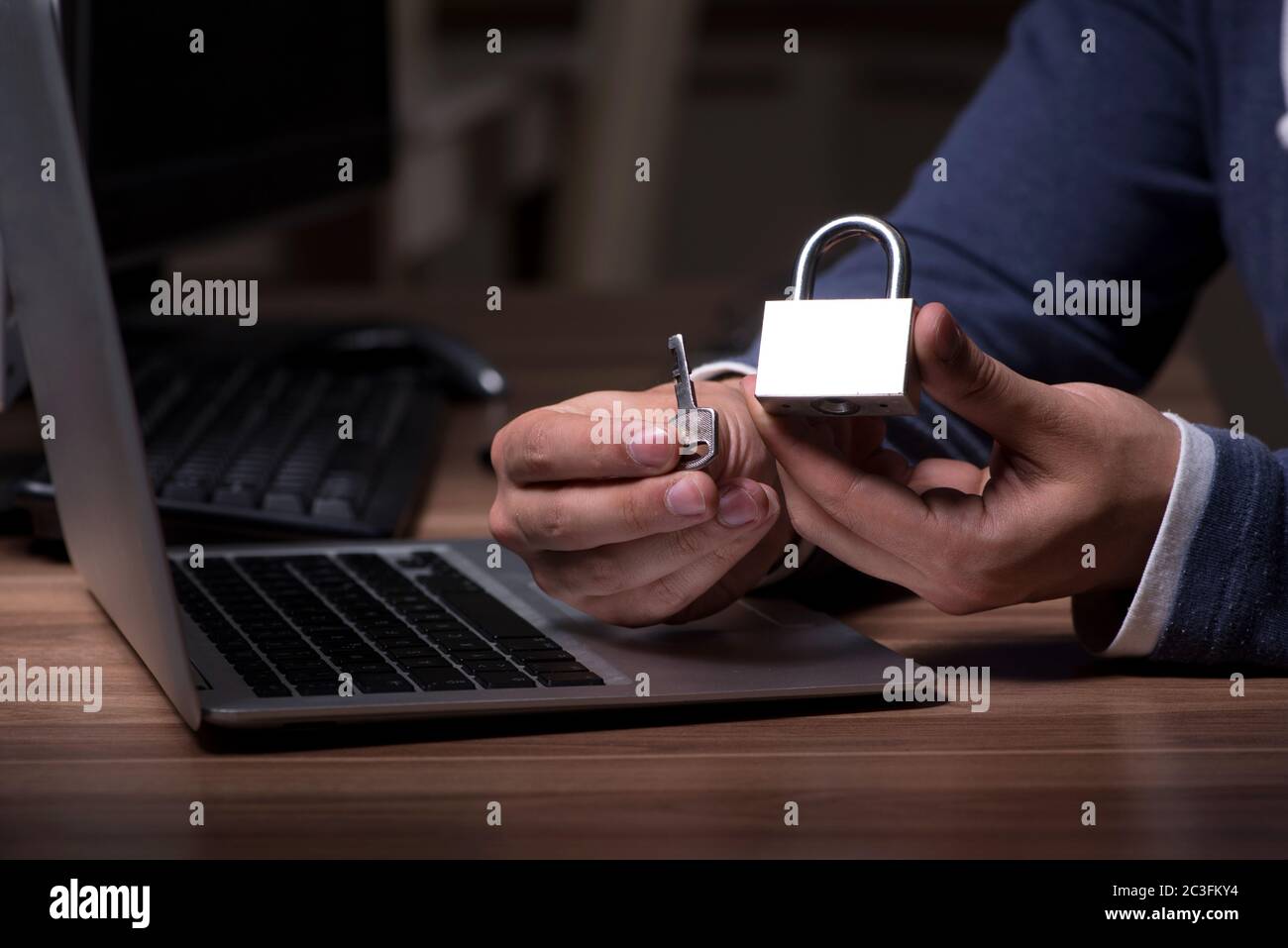 Male hacker hacking security firewall late in office Stock Photo - Alamy