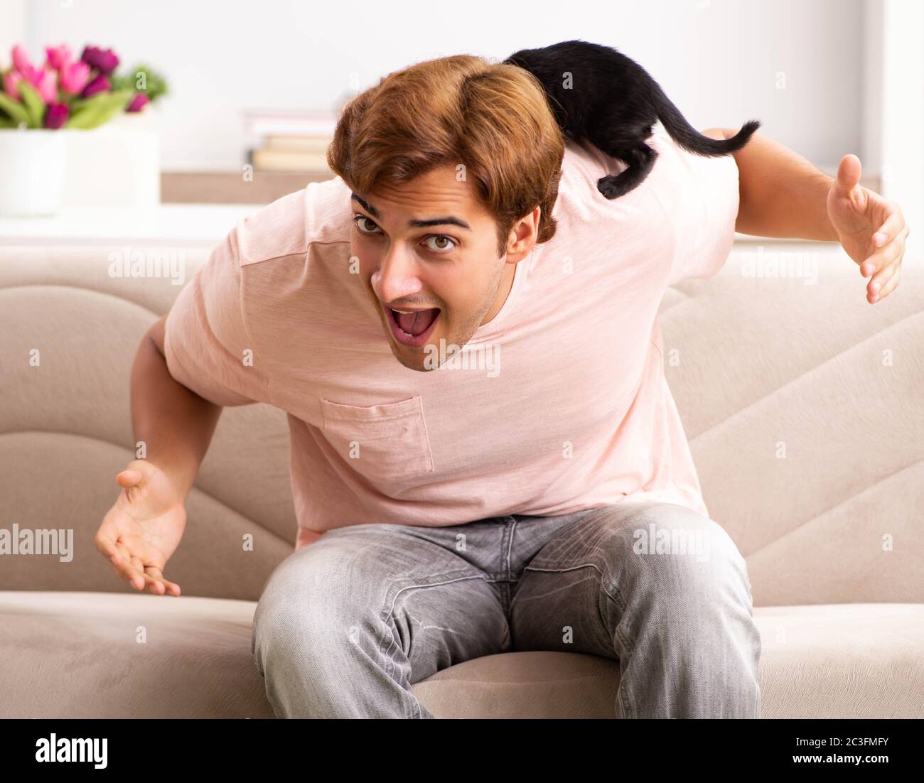 Handsome man playing black cat hi-res stock photography and images - Alamy
