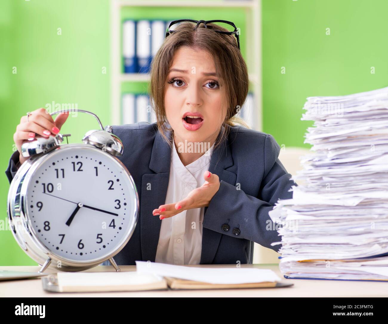 Young female employee very busy with ongoing paperwork in time m Stock ...