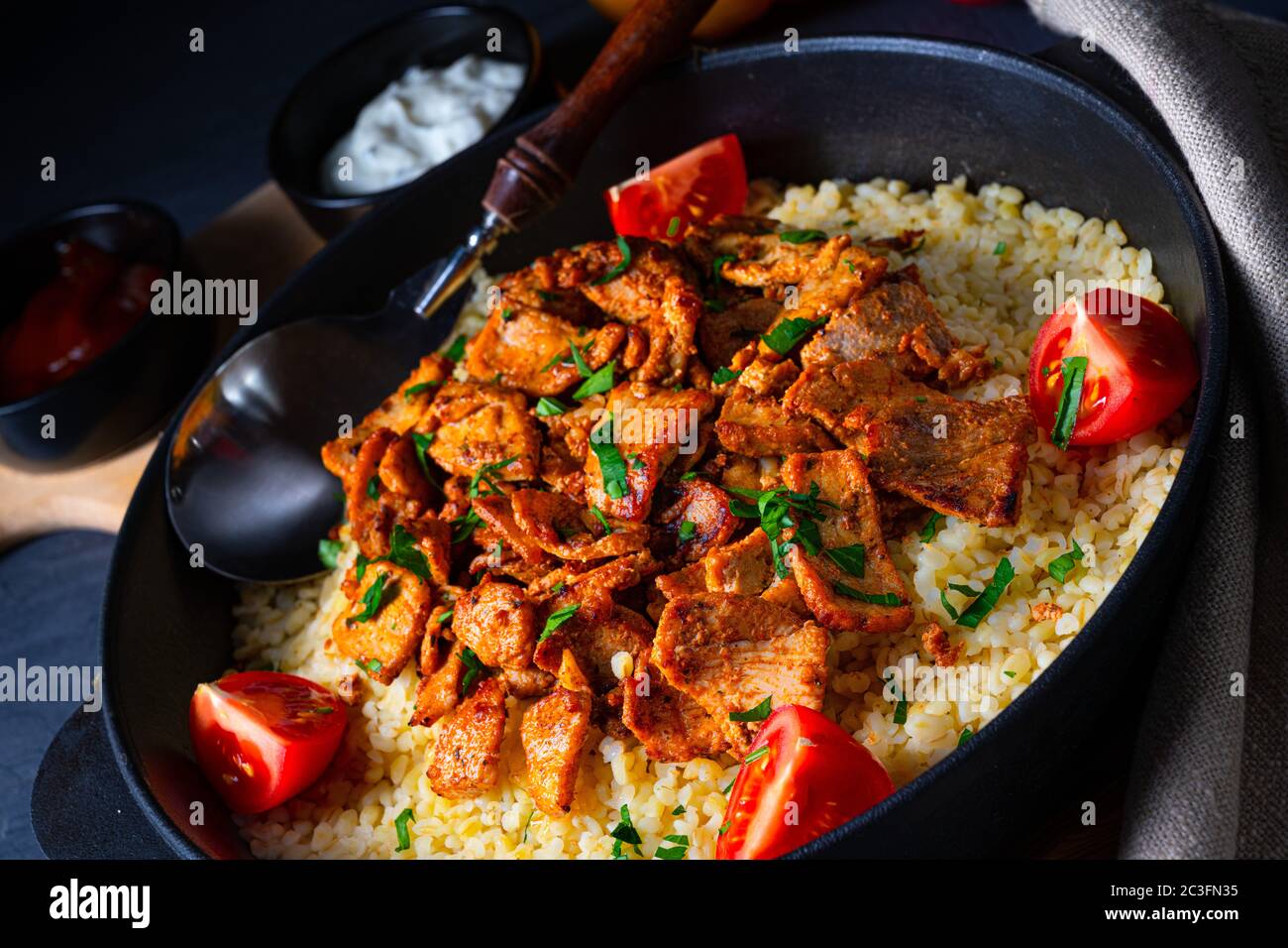 rustic bulgur pans with gratinated gyros and yoghurt Stock Photo - Alamy