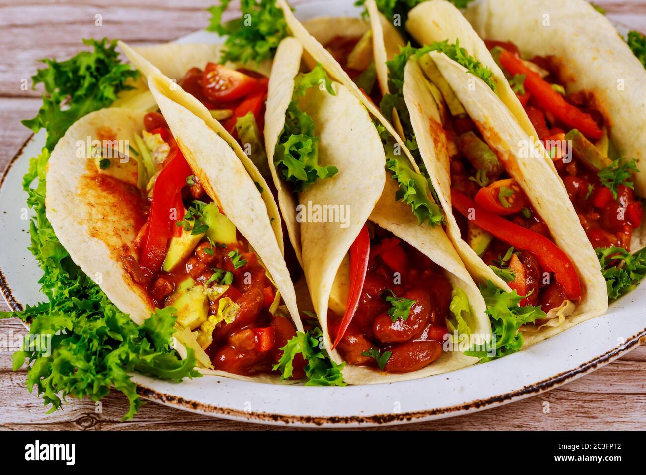 Colorful tortillas with beans, beef and vegetable with salsa. Mexican ...