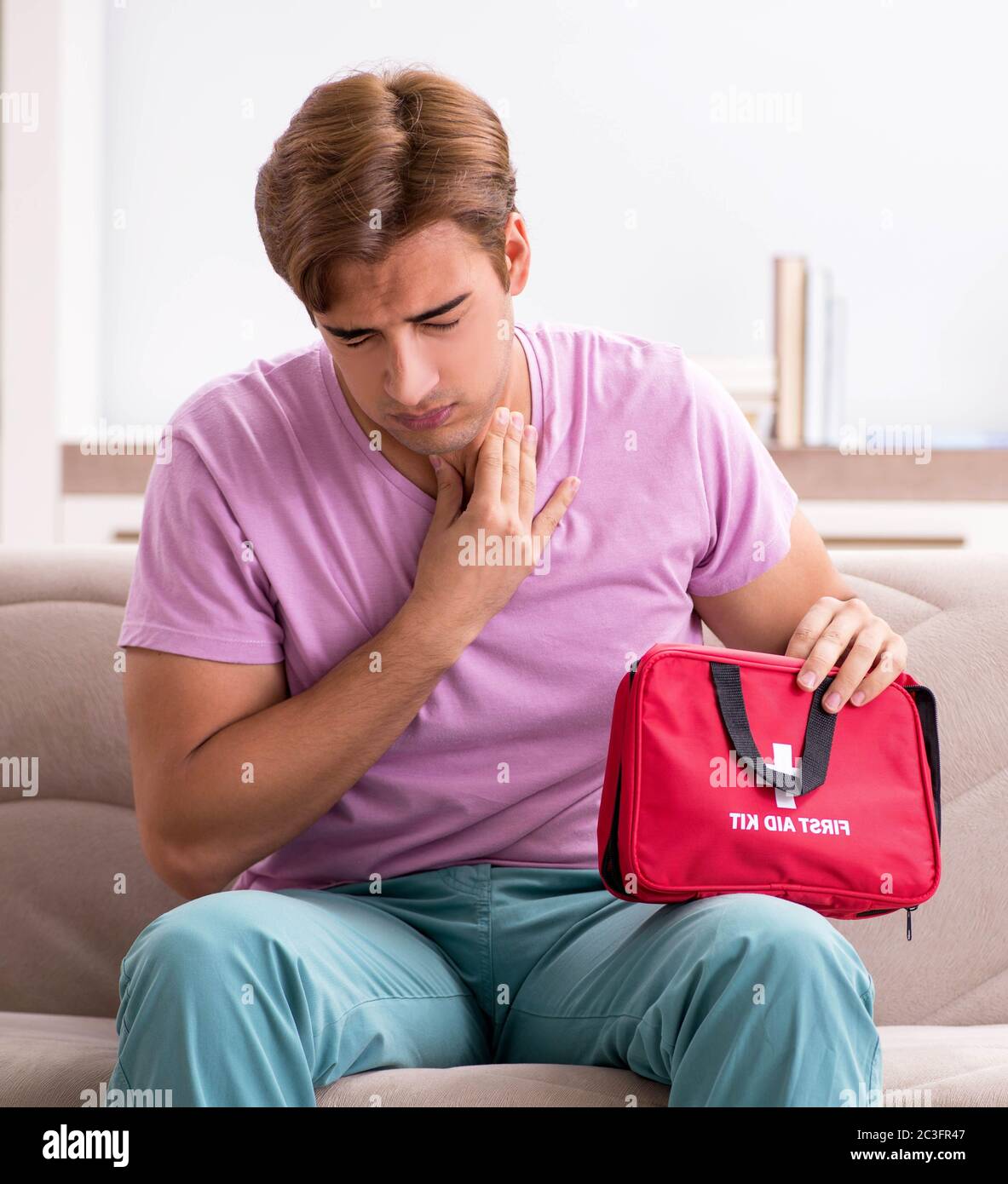 Sick man at home with first aid kit Stock Photo - Alamy