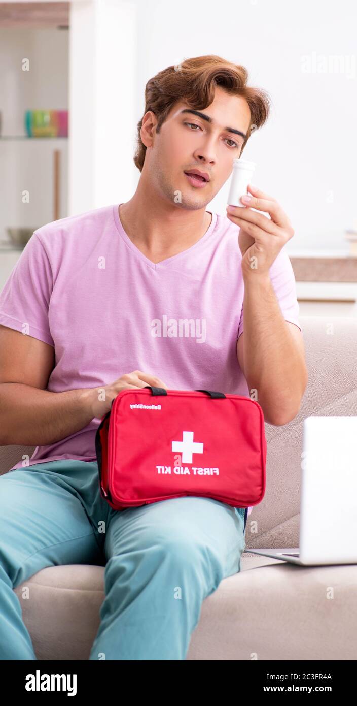 Sick man at home with first aid kit Stock Photo - Alamy