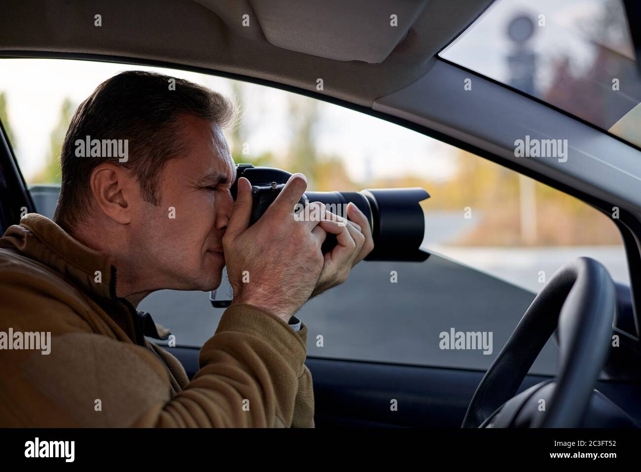 Young man with a dslr camera in a car Stock Photo - Alamy