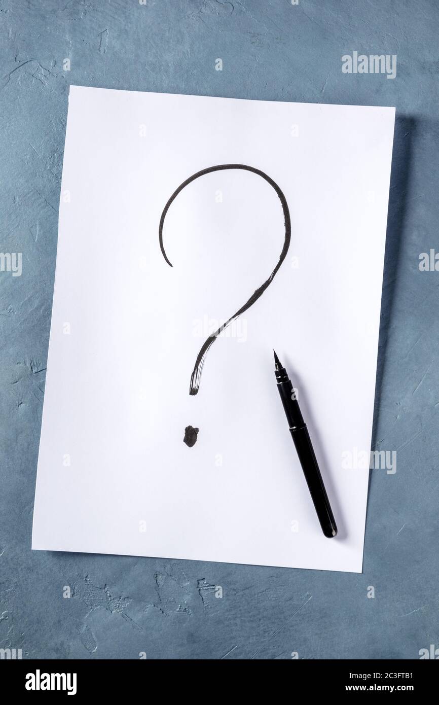 Question mark, written in ink on a piece of standard office paper, shot ...