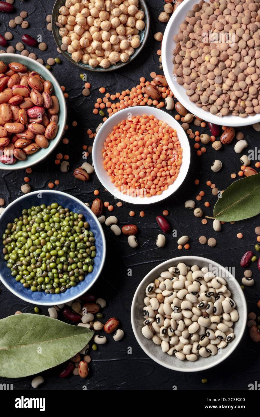 Legumes variety, overhead shot on a black background. Lentils, soybeans ...