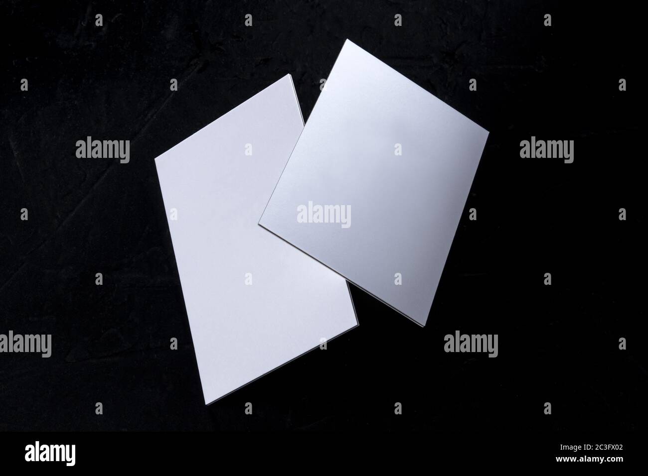 White 3 ply business cards, floating on a black background, a mock-up ...