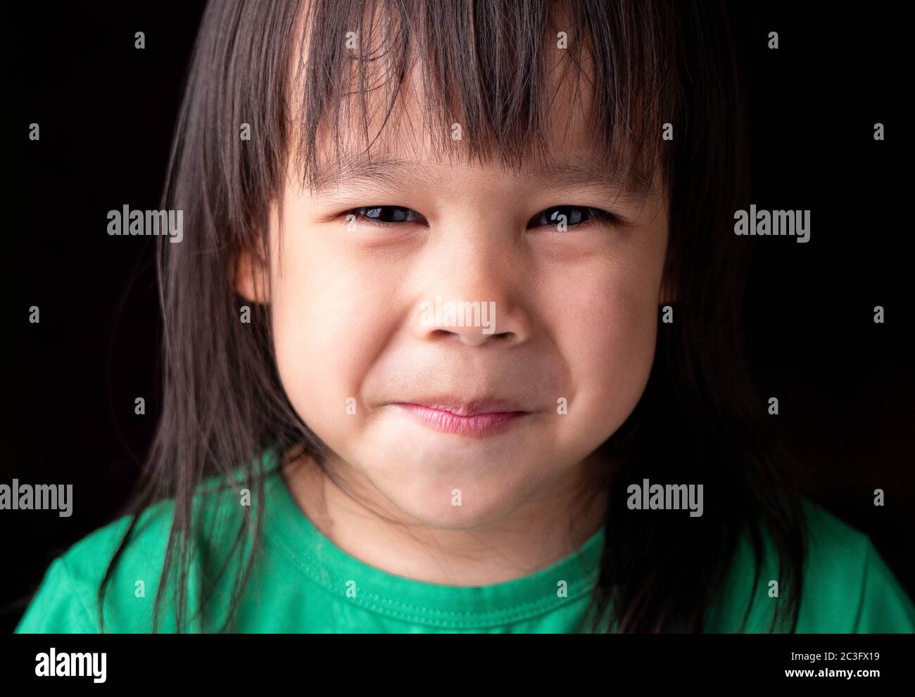Portrait face of Asian little child girl with happy expression on dark ...