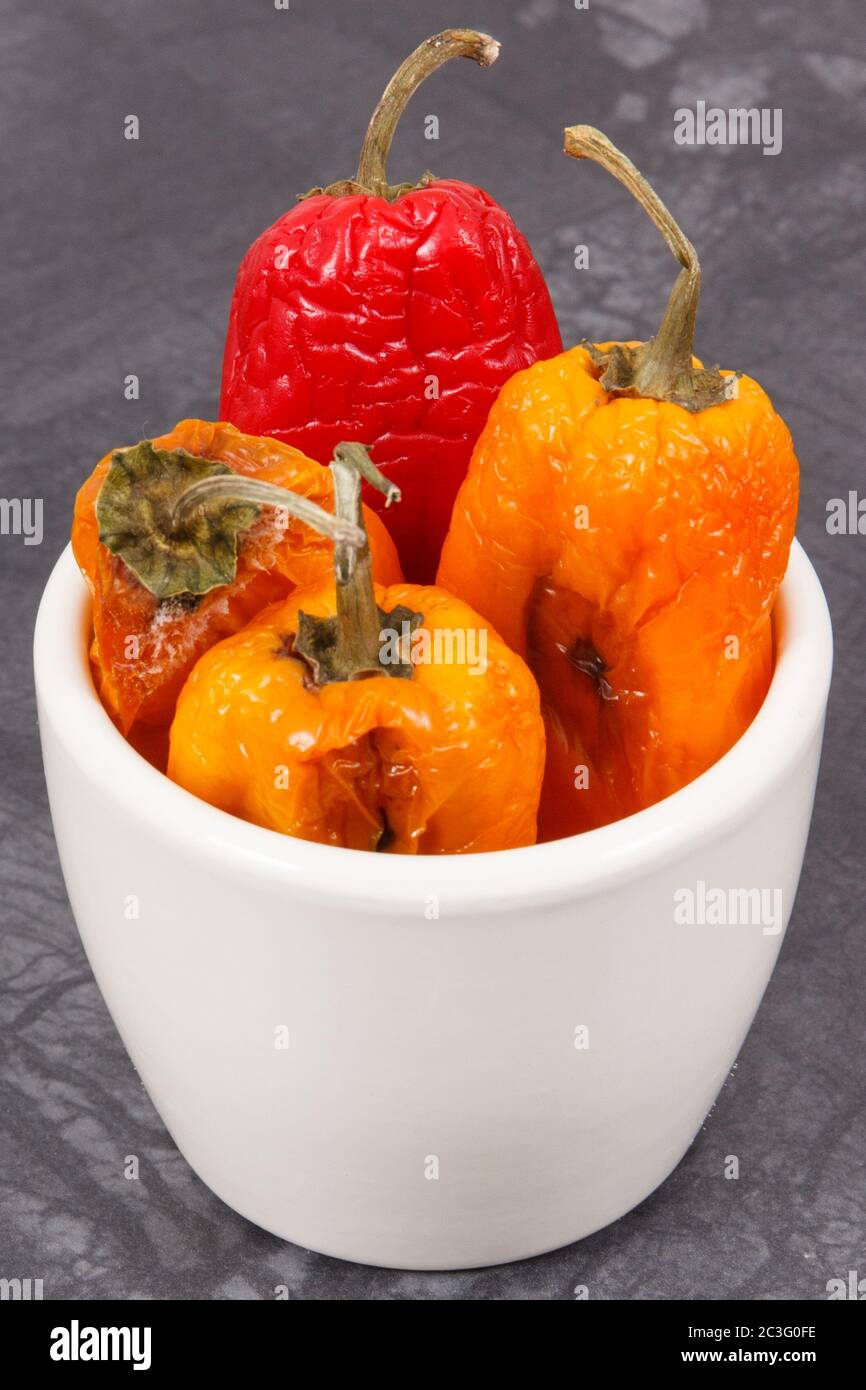 Moldy and wrinkled peppers in white bowl. Concept of unhealthy ...