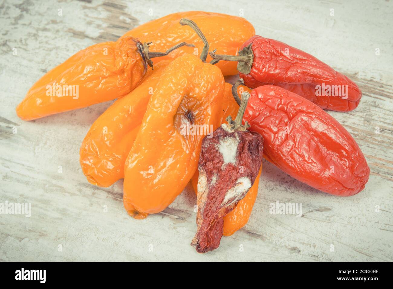 Old wrinkled moldy peppers on old rustic board, concept of unhealthy ...